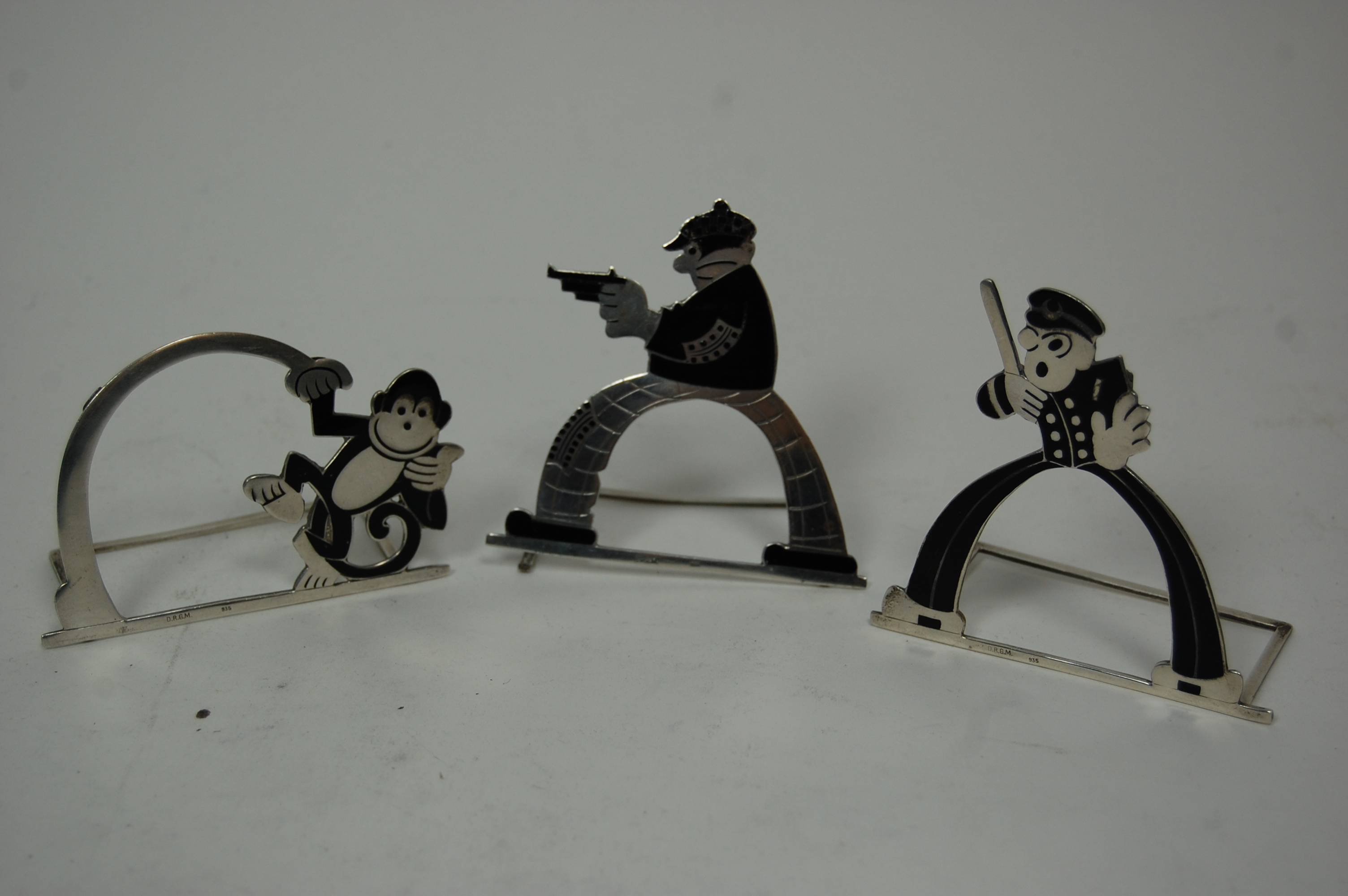 POLICE INTEREST - A set of three amusing silver and enamel place card ...